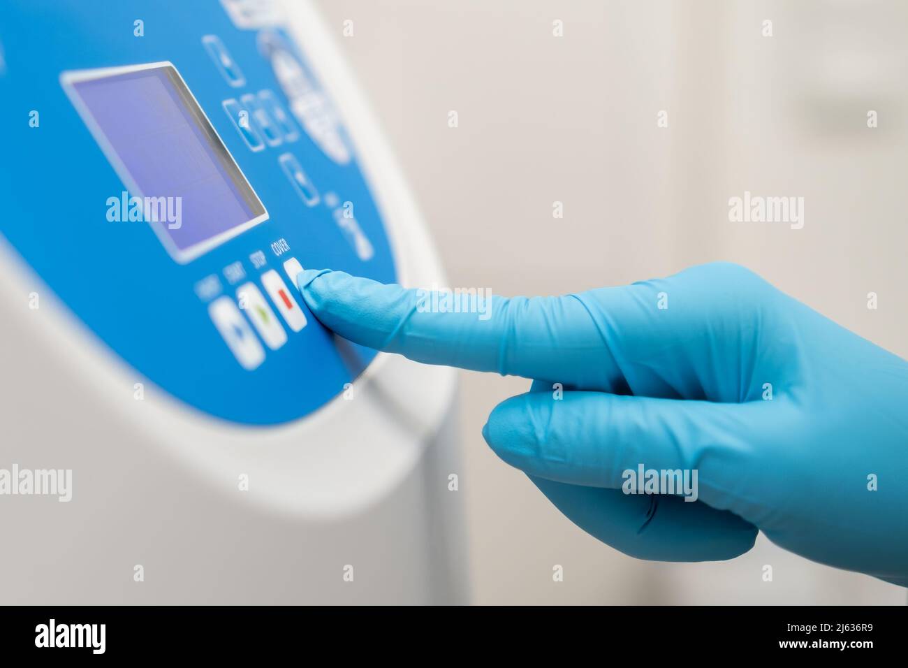 Close up laboratory worker hand in rubber gloves sets parameters on the ...
