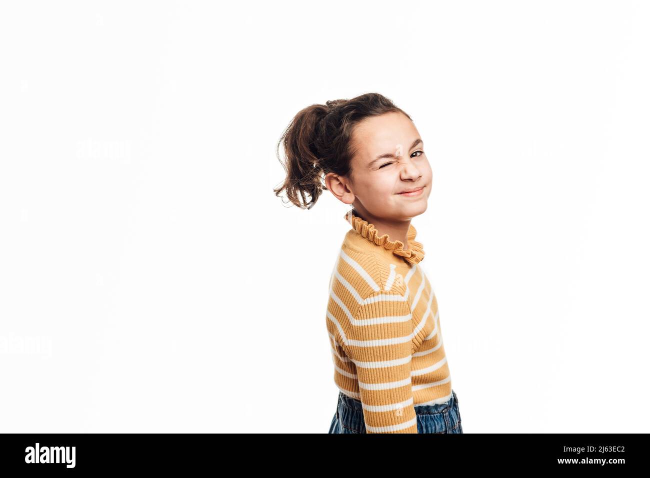 Girl looking at camera and winking an eye while posing over an isolated ...