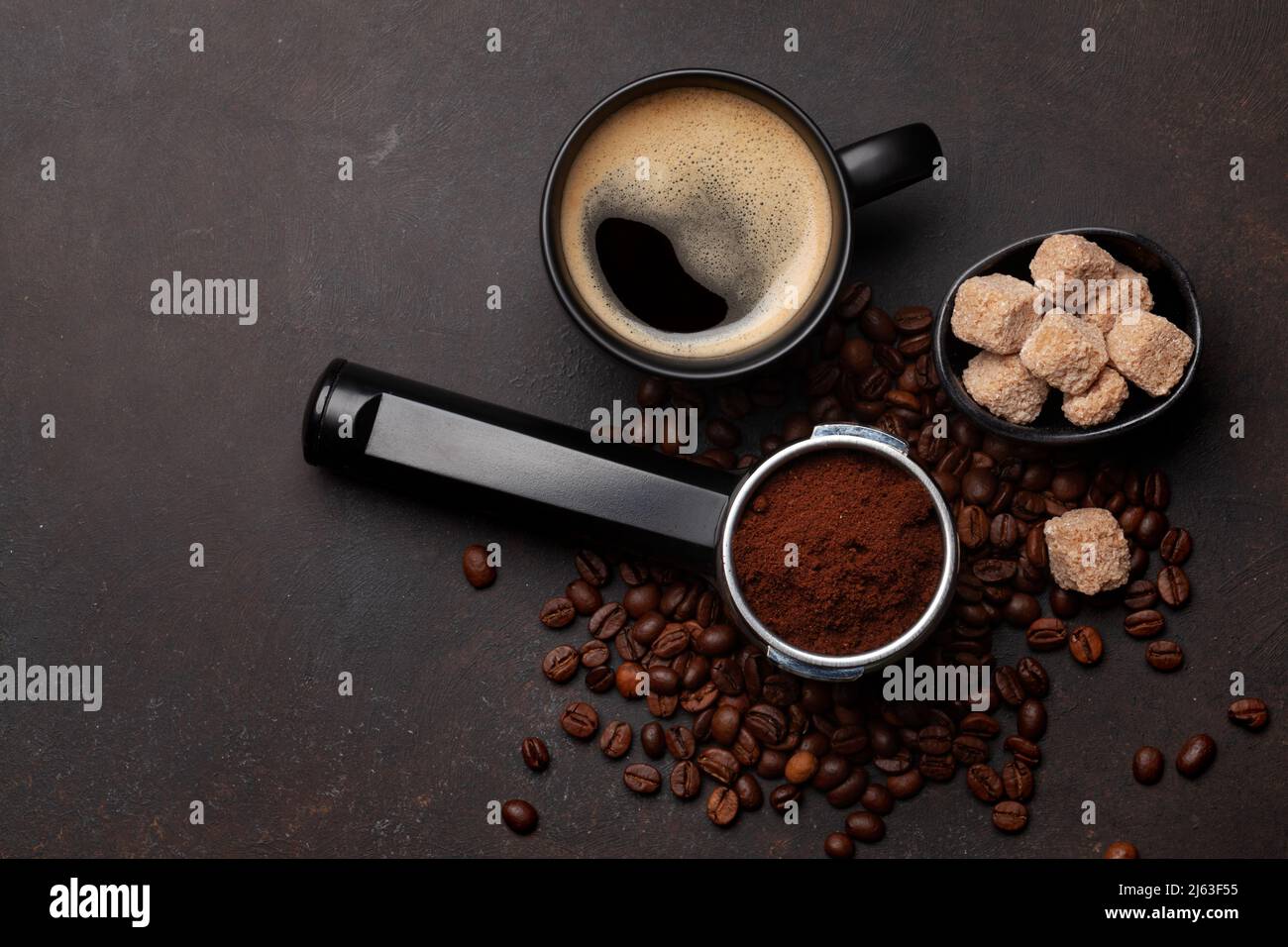 Roasted coffee beans, ground coffee in filter holder and espresso cup ...