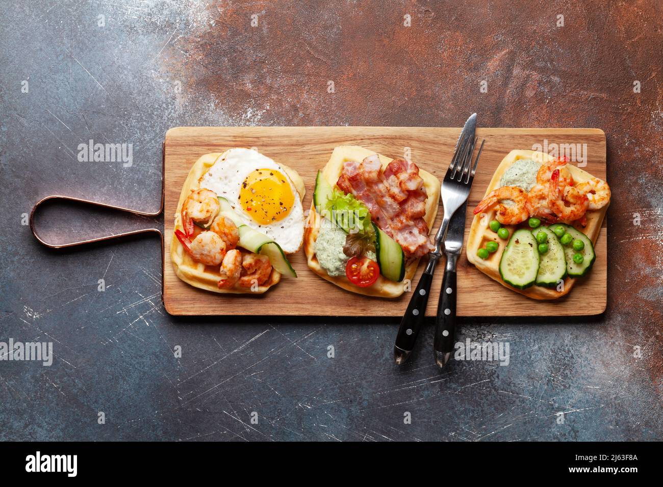 Breakfast waffles with fried eggs, salmon, bacon, cucumber and prawns ...