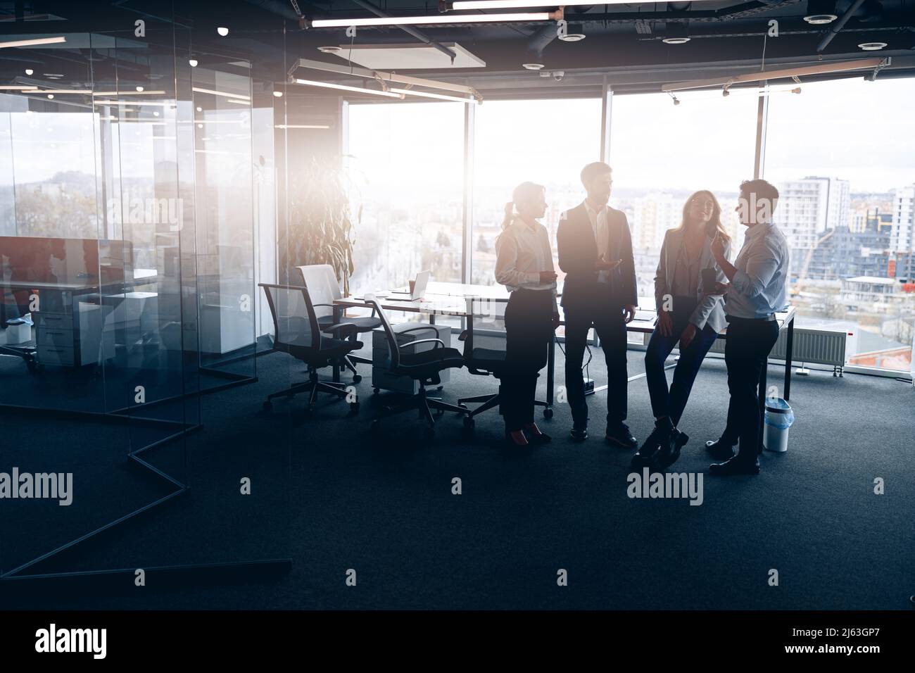 Business team standing against panoramic windows in modern office Stock ...