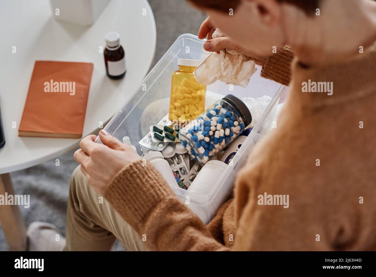 High angle medium close-up shot of unrecognizable woman suffering fever ...