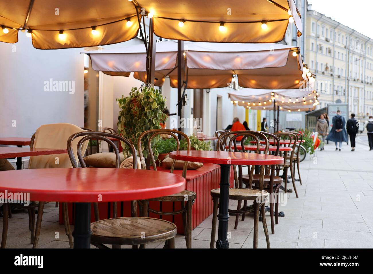 Street cafe with red tables and vintage wooden chairs outdoor ...