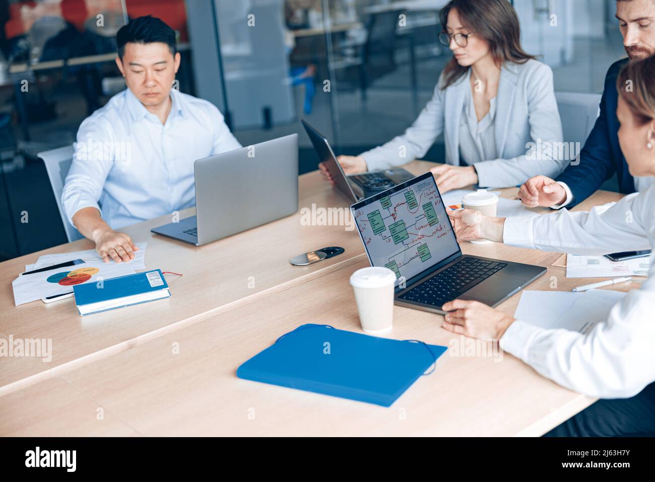 Focused business people are using gadgets and talking during the ...