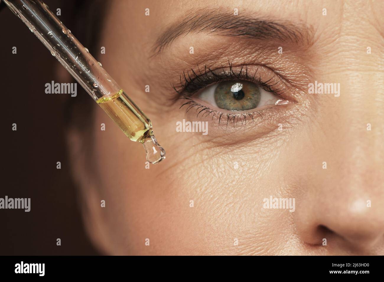 Female eye and dropper with rejuvenating serum Stock Photo - Alamy
