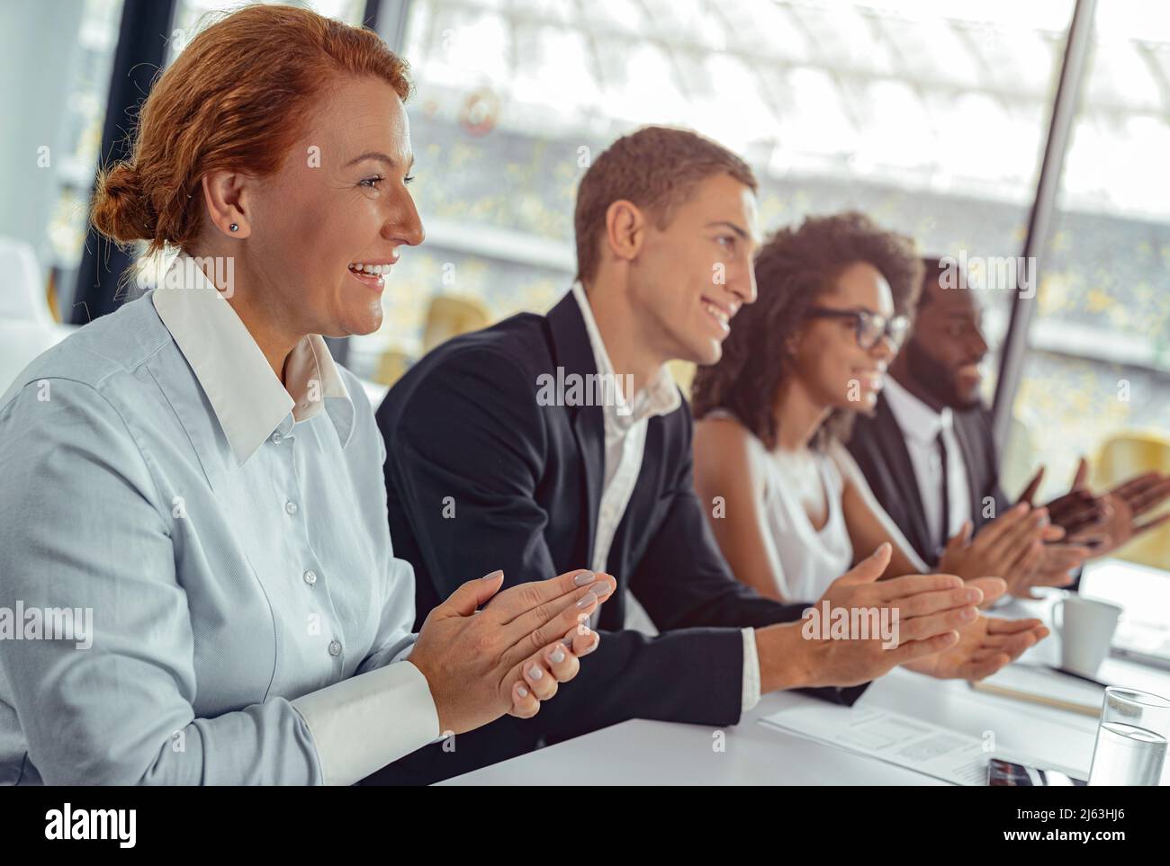 Business team clapping hands while sitting at the table in office Stock ...
