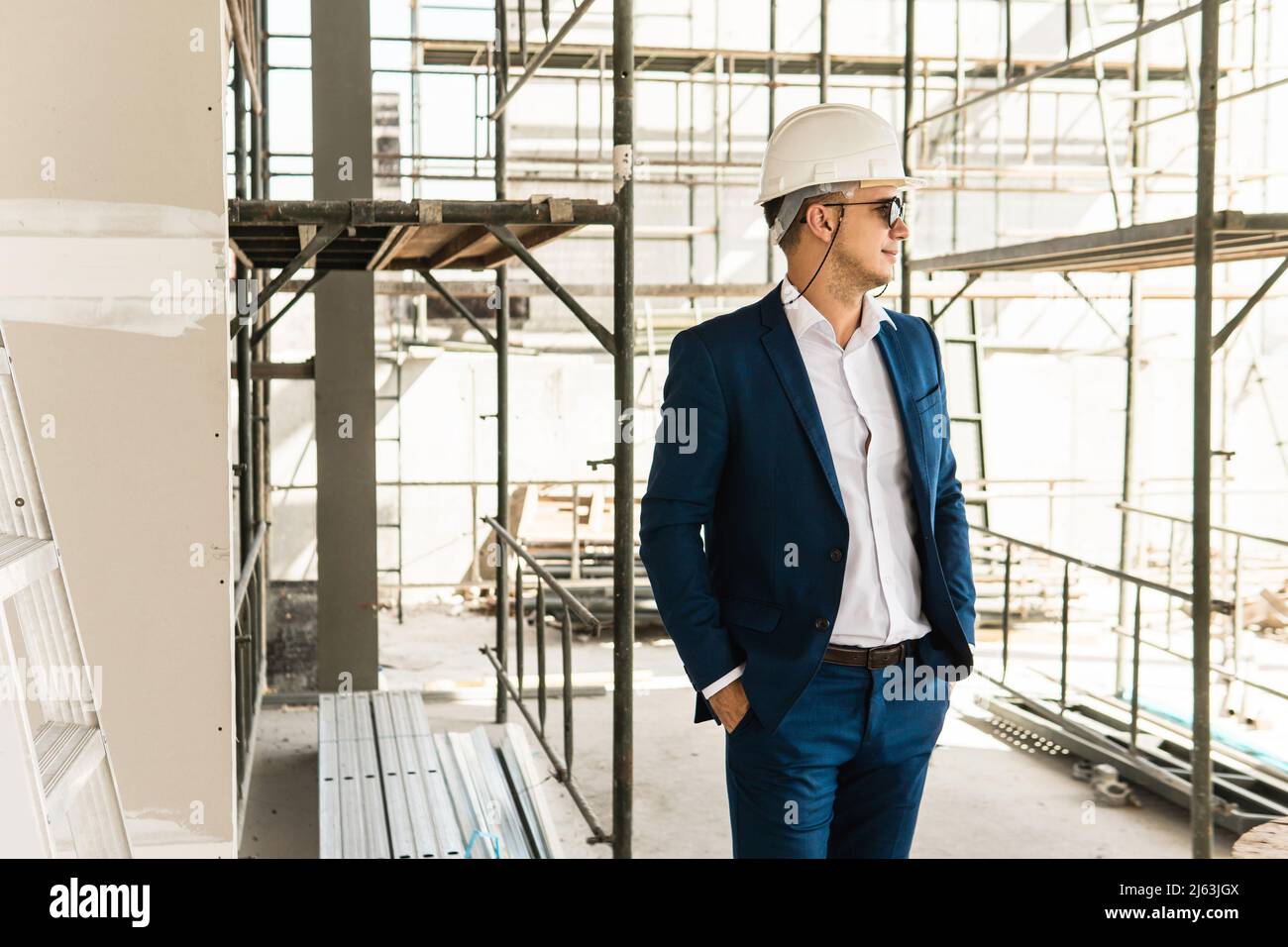Architect or businessman wearing formal suit and hard hat on a ...