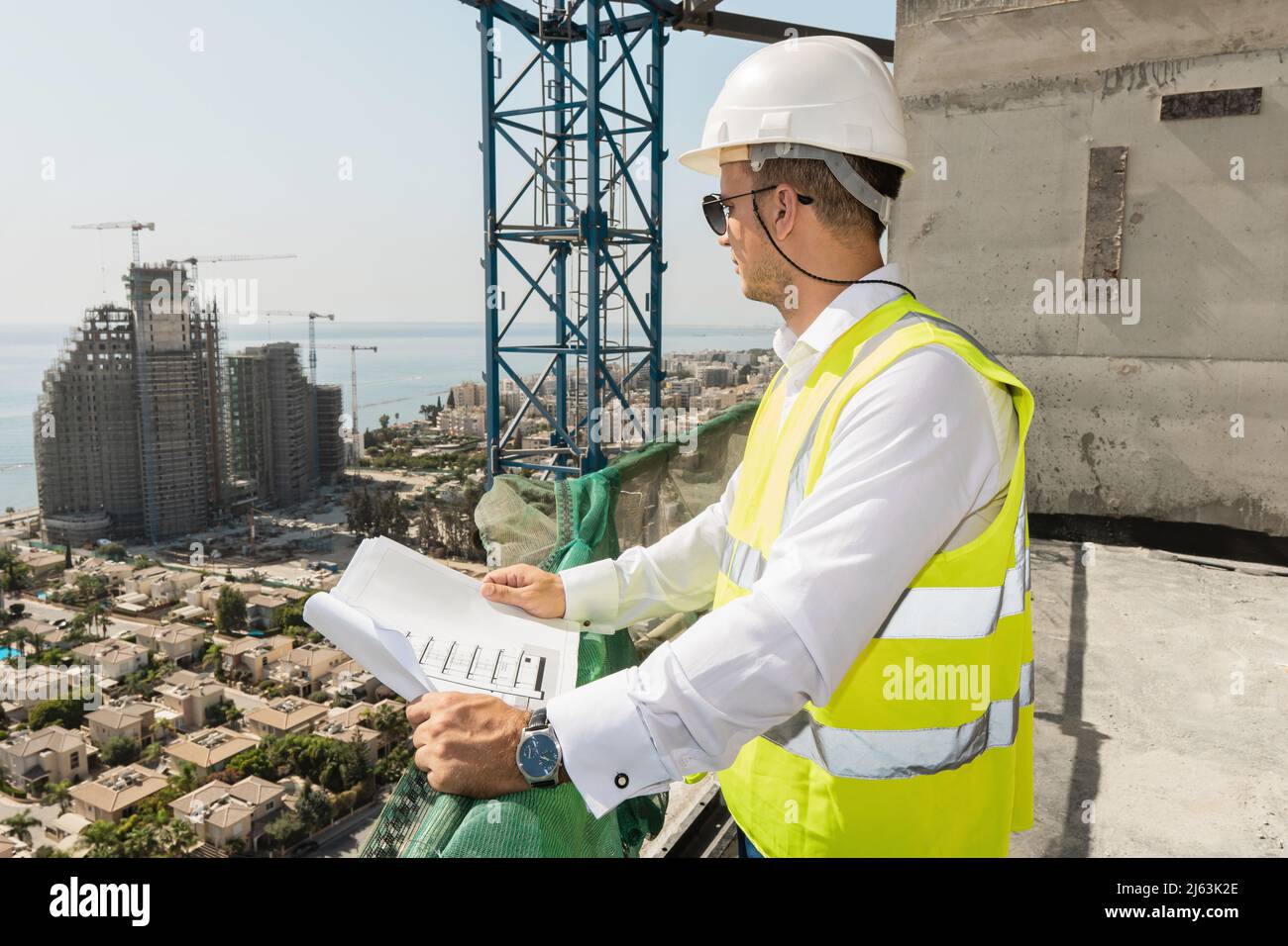 Engineer or architect wearing reflective vest and hard hat on a ...