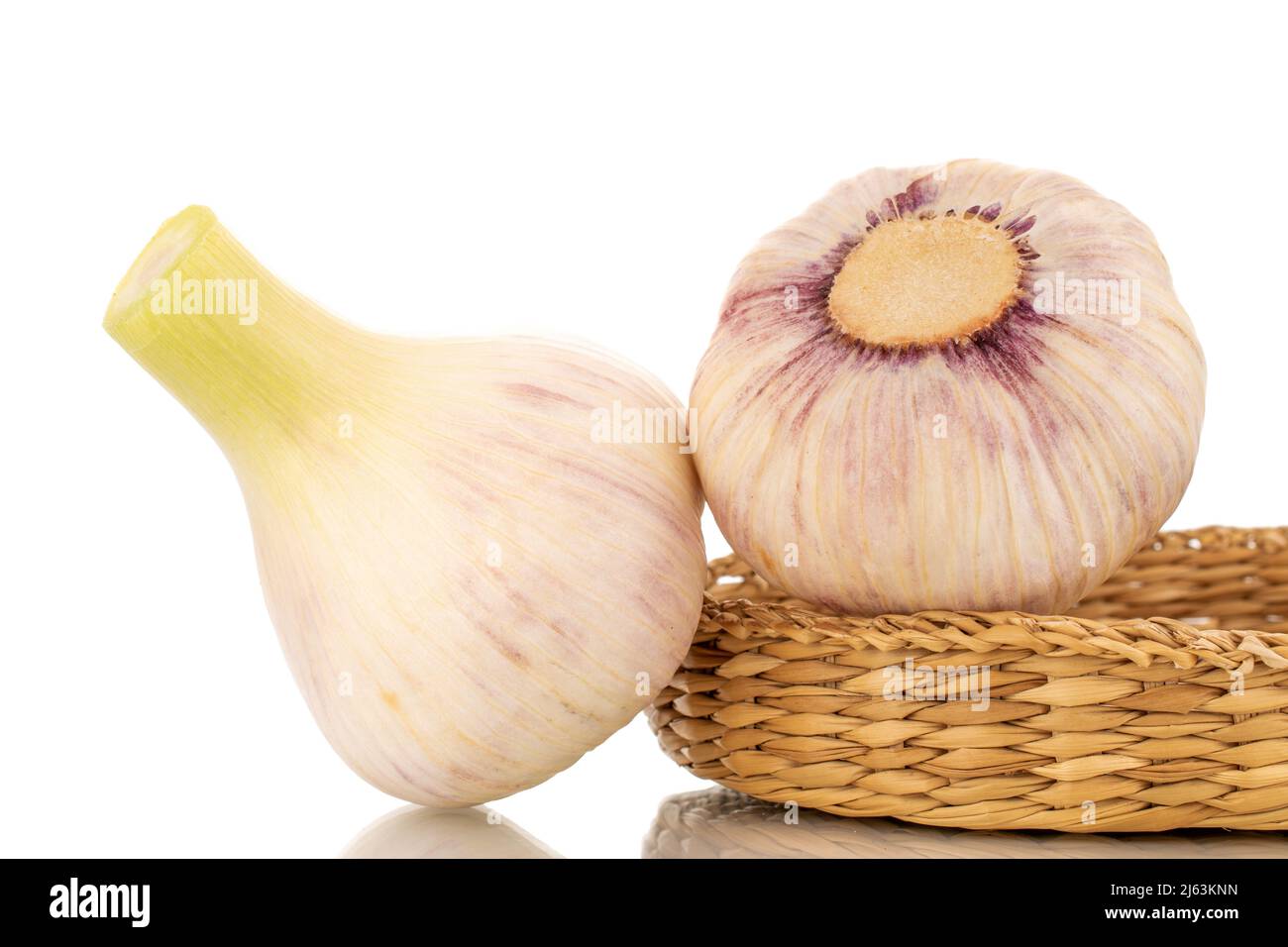 Two heads of early garlic with a straw plate, close-up, isolated on a ...