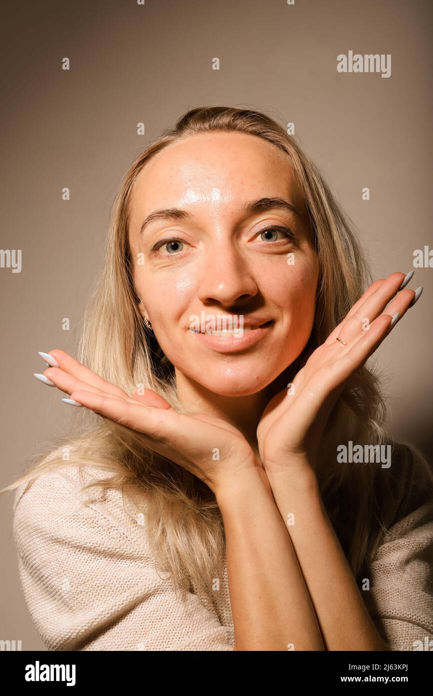 A young woman holds her palms near her face and smiles Stock Photo - Alamy