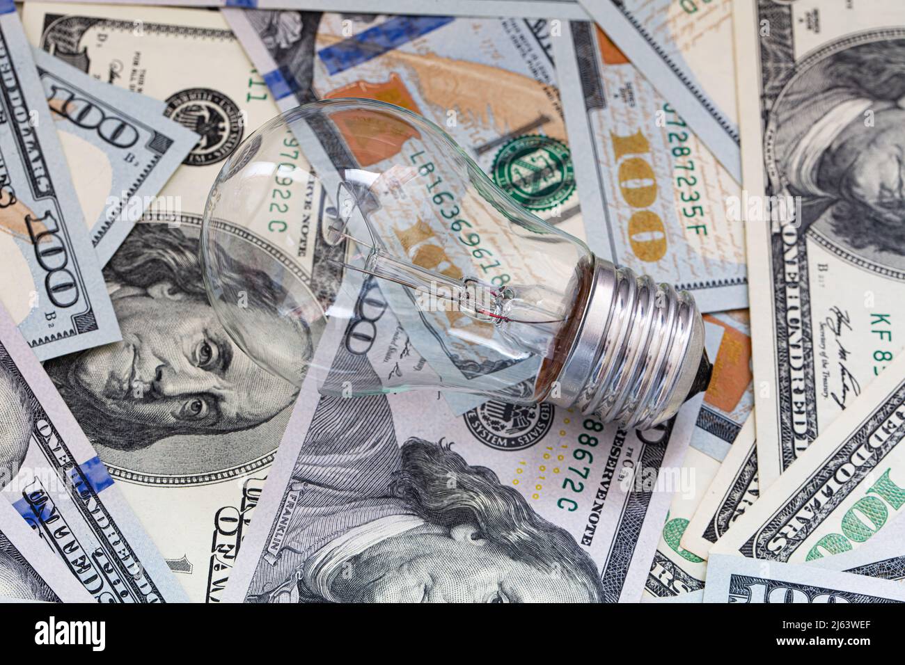 Incandescent light bulb on US 100 dollar background for desing purpose ...