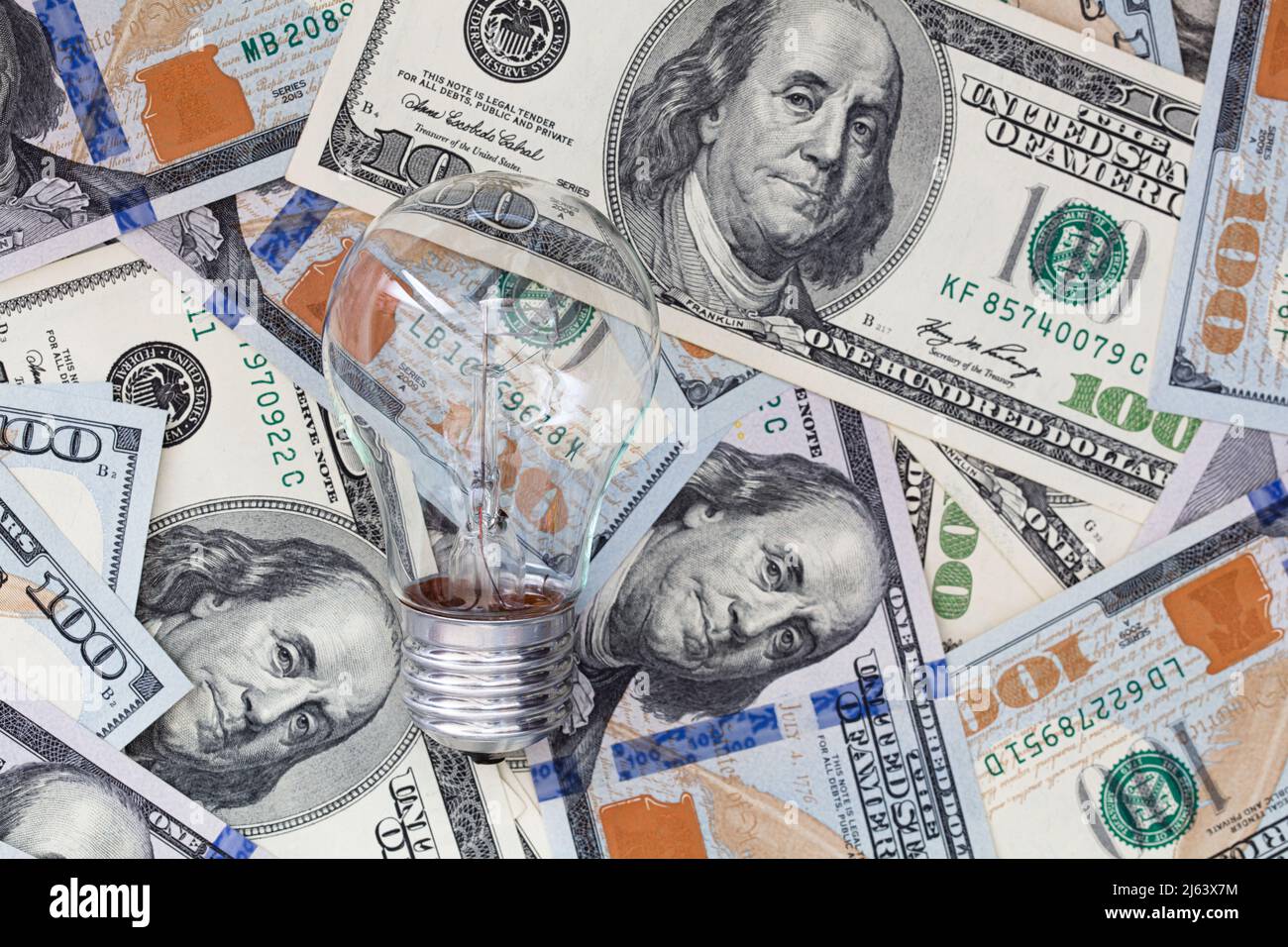 Incandescent light bulb on US 100 dollar background for desing purpose ...