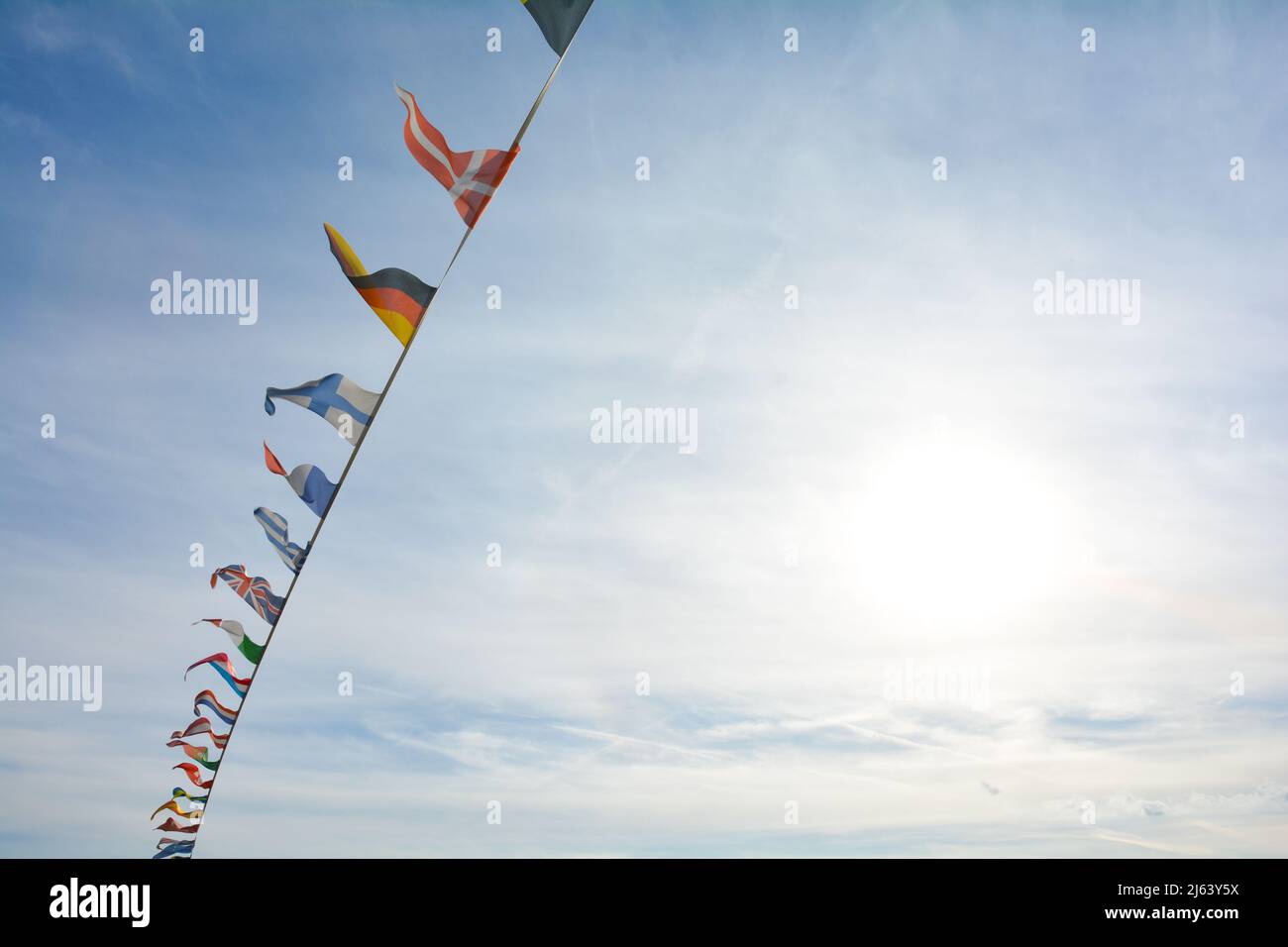 Flags from several different countries hang from a rope, against a lot ...
