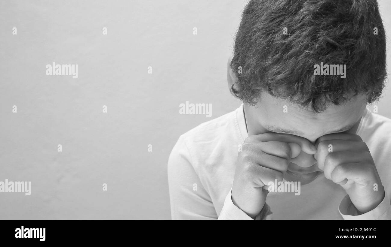 little boy praying to God with hands together with people stock photo ...