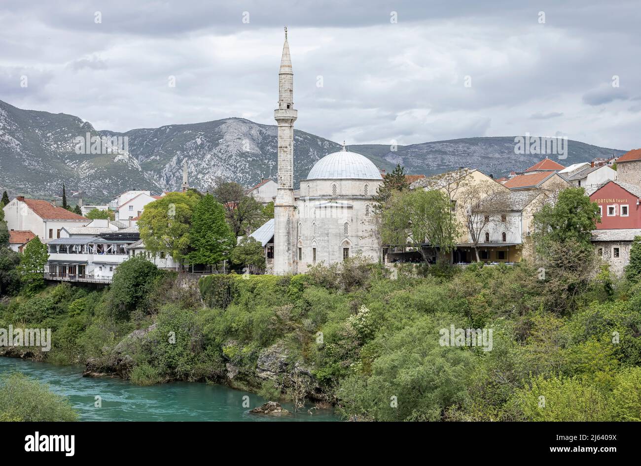 Looking down a turquoise river at Mosque and a minuet againsta angry ...