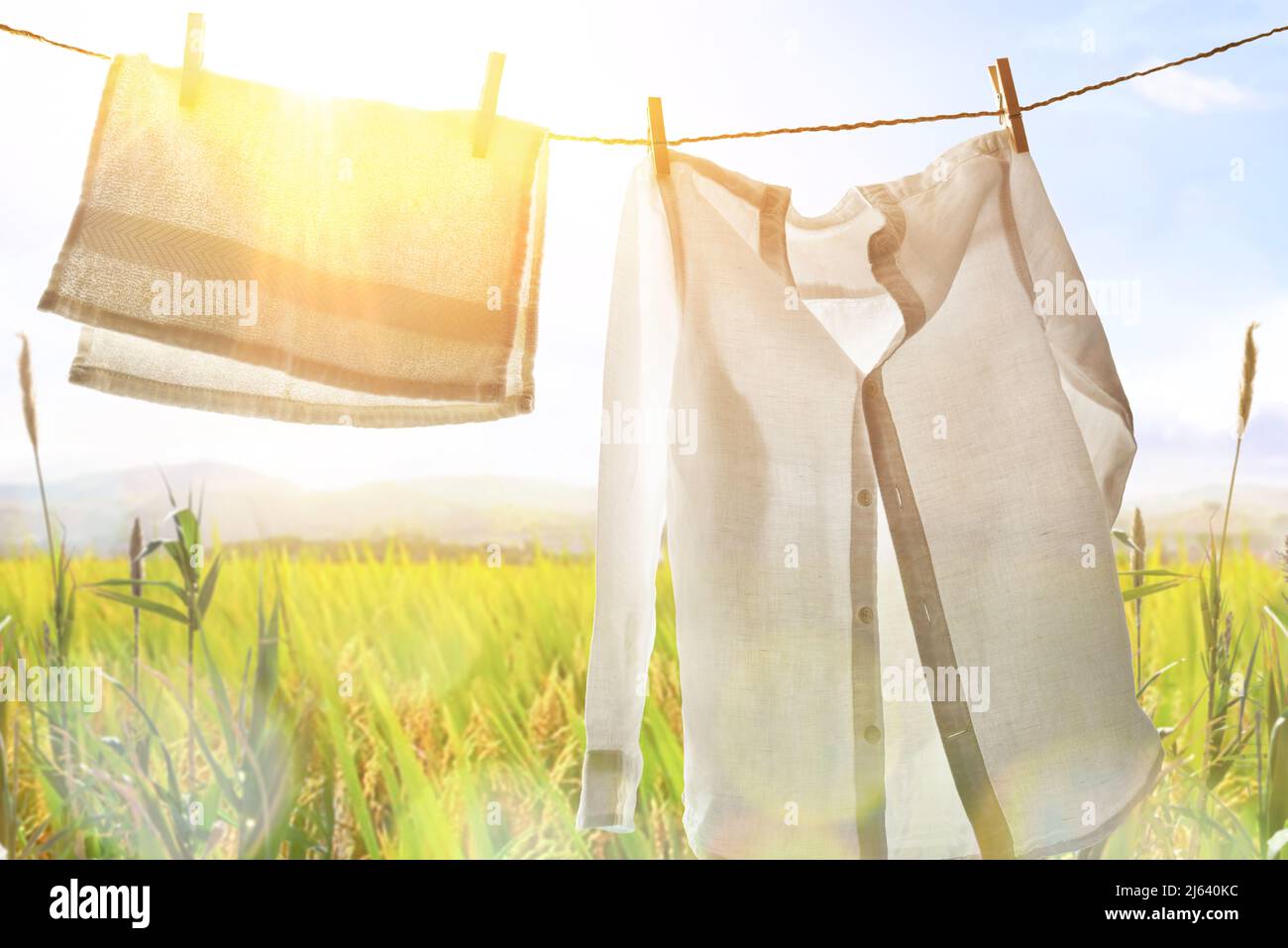 White clothes hanging backlit outdoors with sunny landscape background ...
