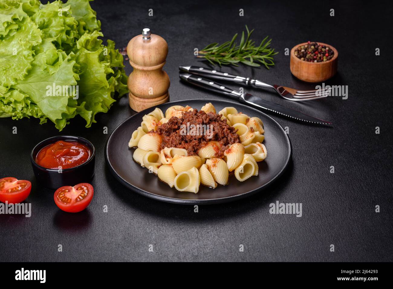 Pasta pappardelle with beef ragout sauce in black bowl. Dark background ...