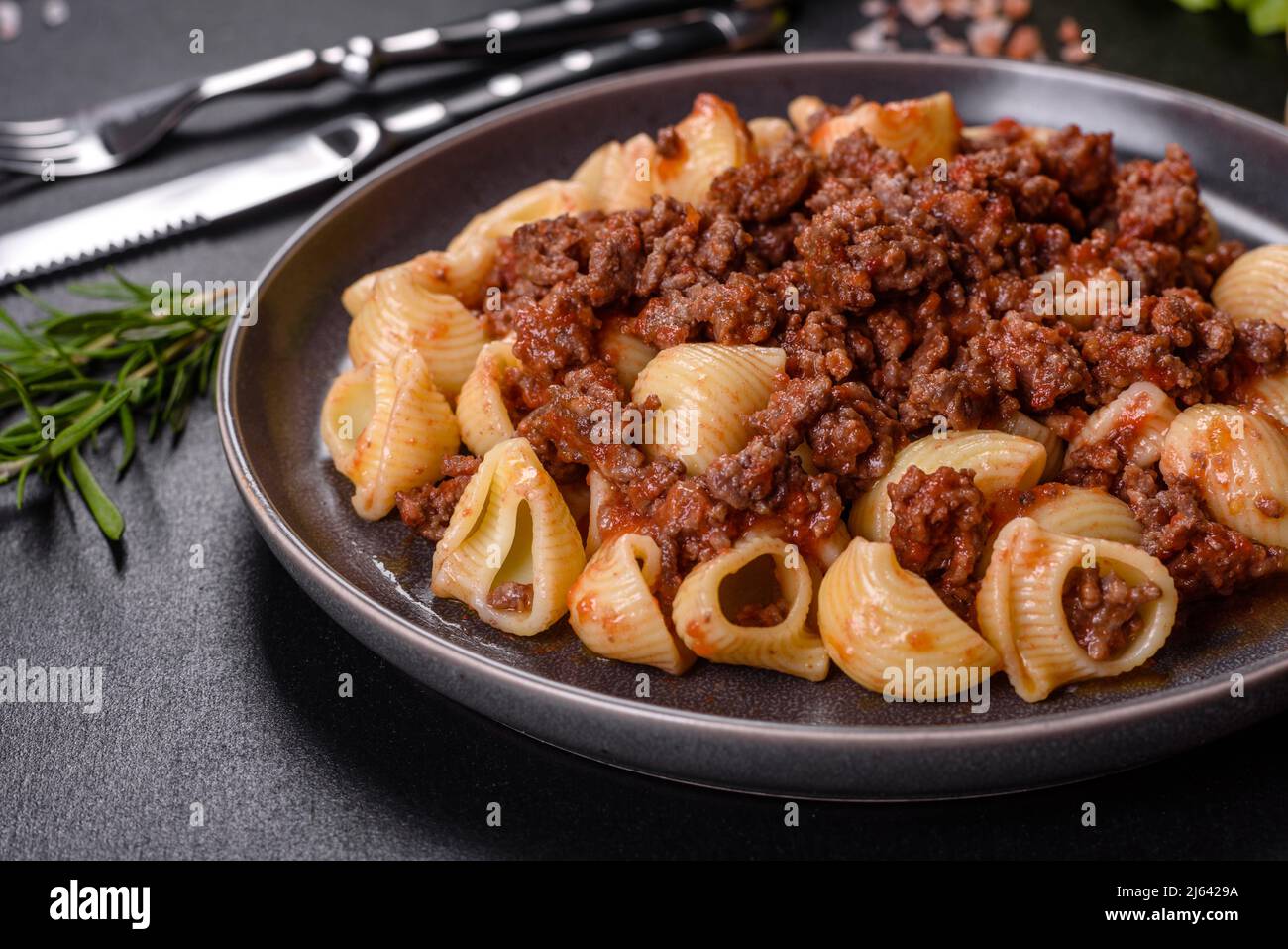 Pasta pappardelle with beef ragout sauce in black bowl. Dark background ...