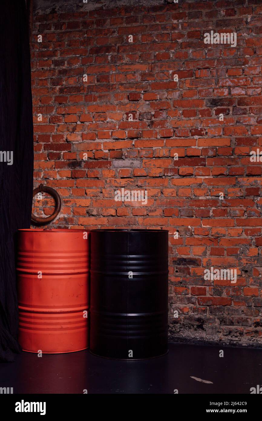 Two barrels of red and black stand against the background of a brick ...