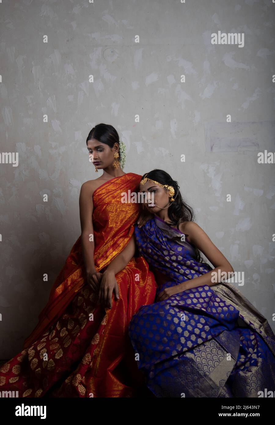 two indian women in traditional Indian orange and blue saree Stock ...