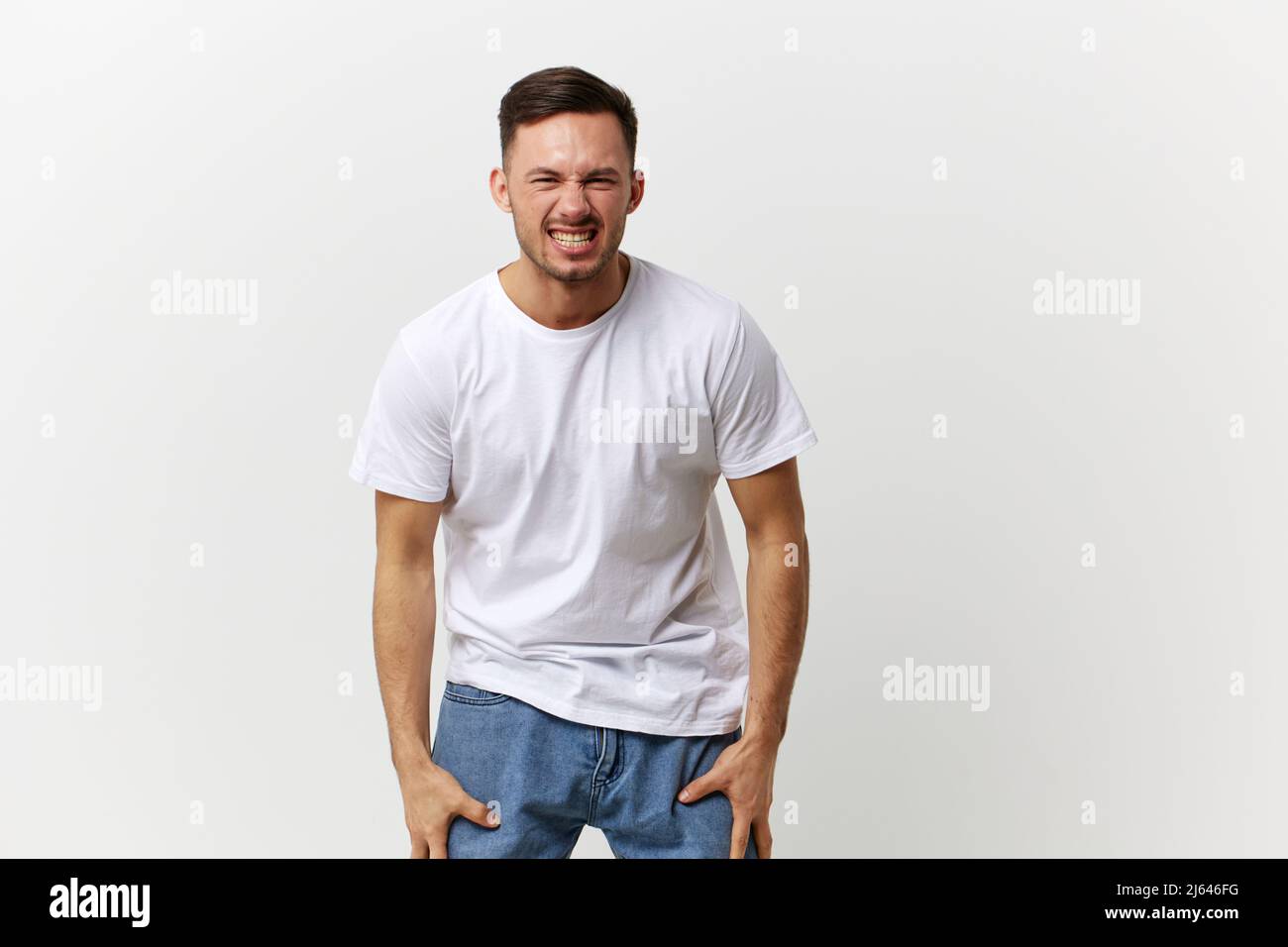 Aggressive evil tanned handsome man in basic t-shirt scream at camera ...