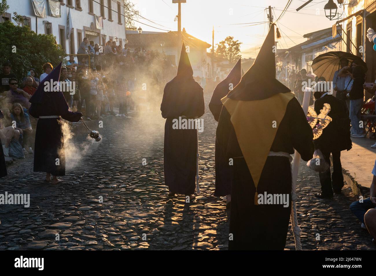 Roman Catholic hooded penitents wearing traditional capirotes, hold a ...