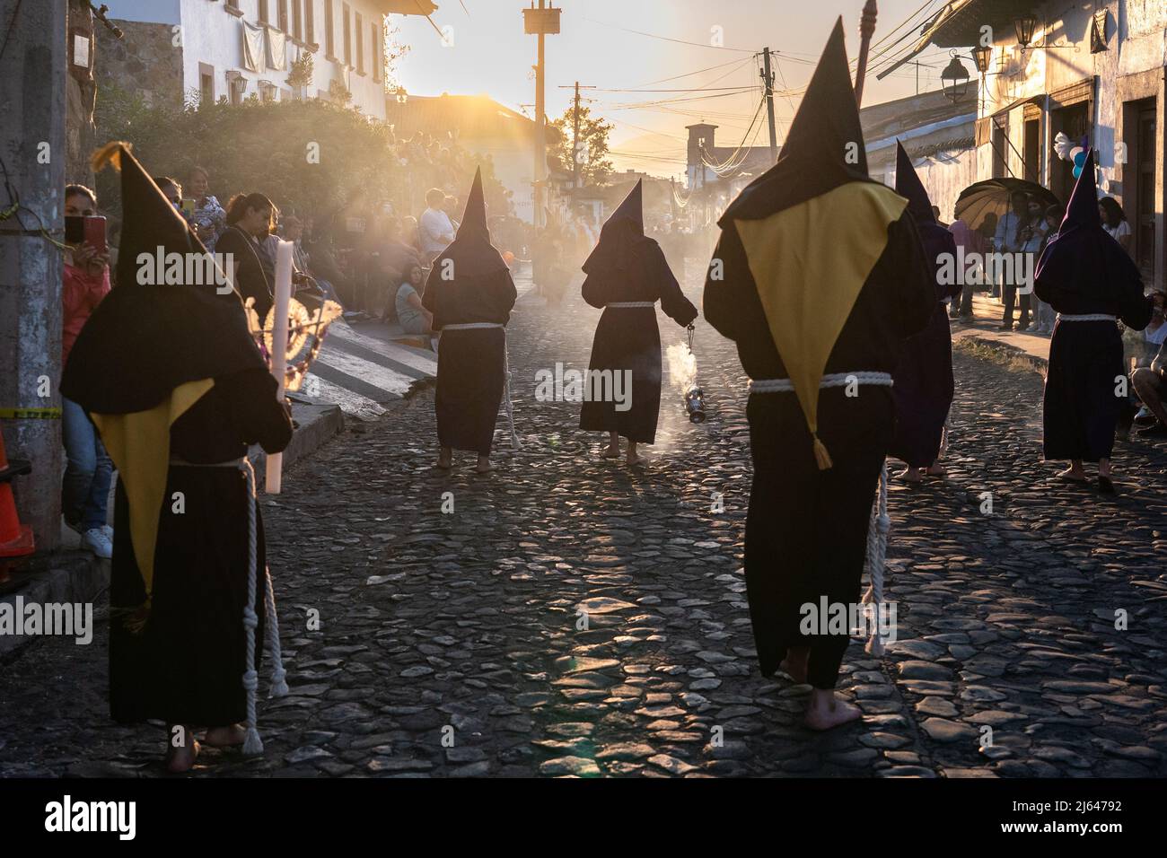 Roman Catholic hooded penitents wearing traditional capirotes, hold a ...