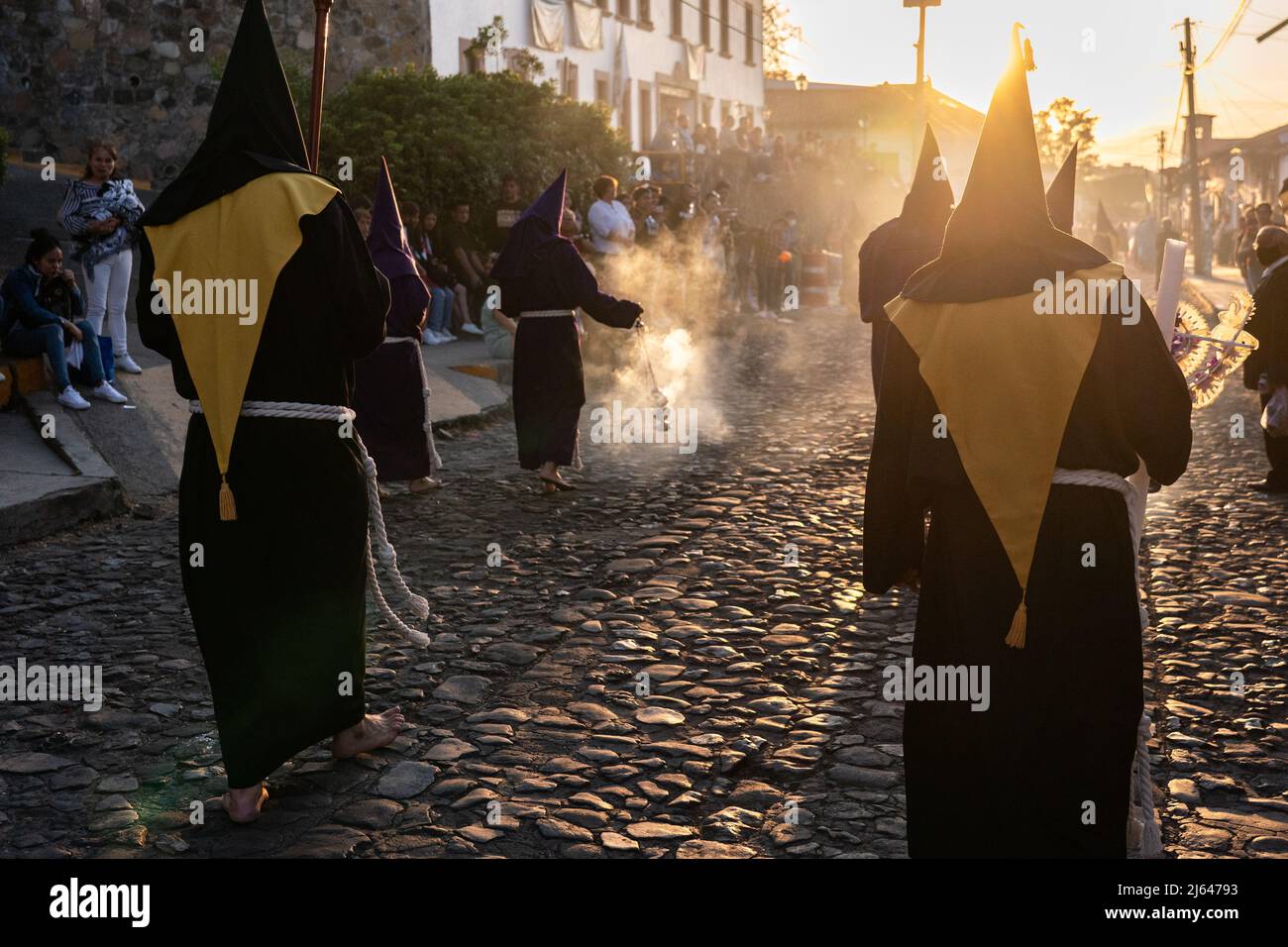 Roman Catholic hooded penitents wearing traditional capirotes, hold a ...