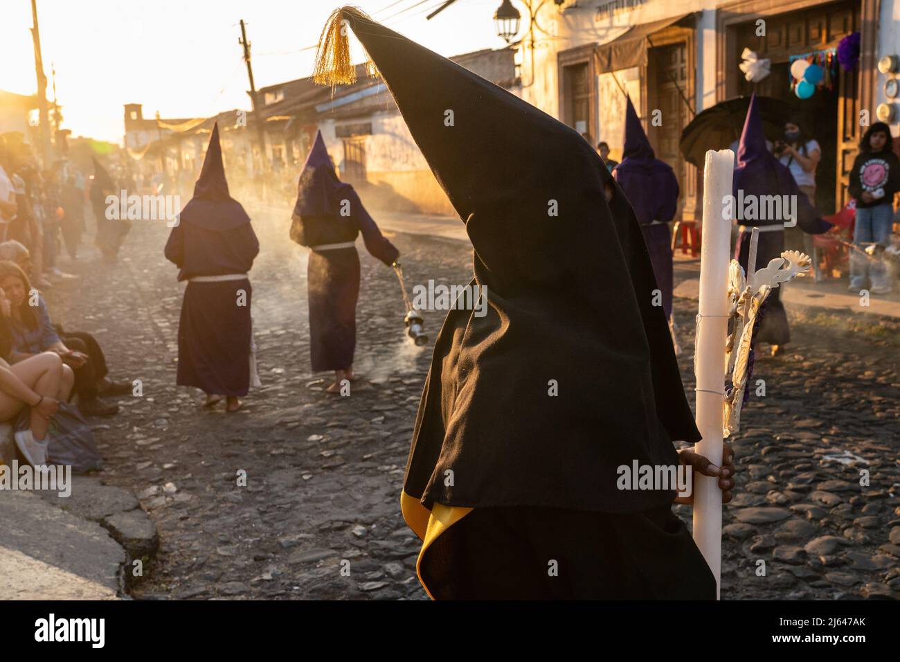 Roman Catholic hooded penitents wearing traditional capirotes, hold a ...