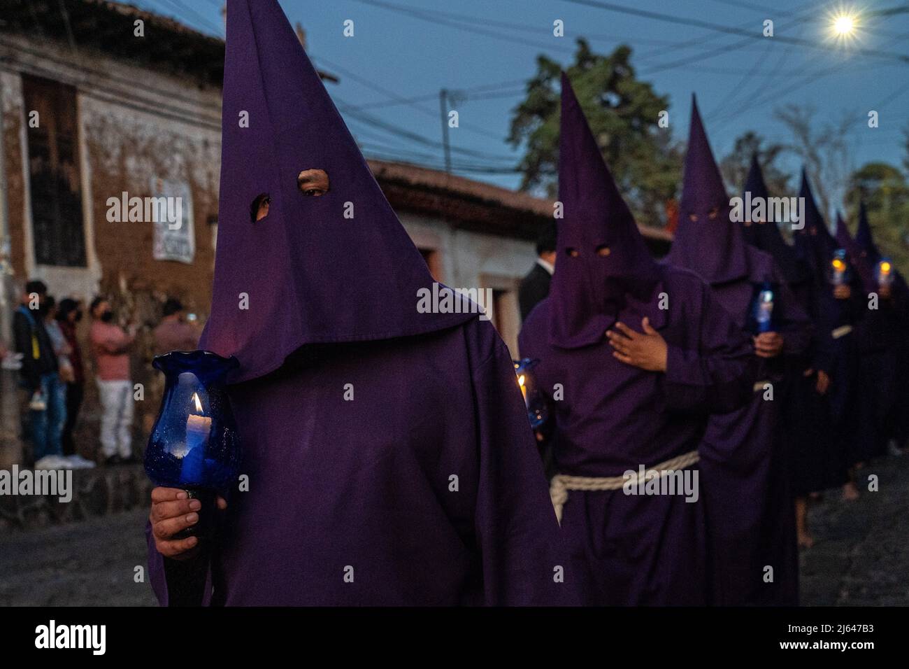 Roman Catholic hooded penitents wearing traditional capirotes, hold a ...