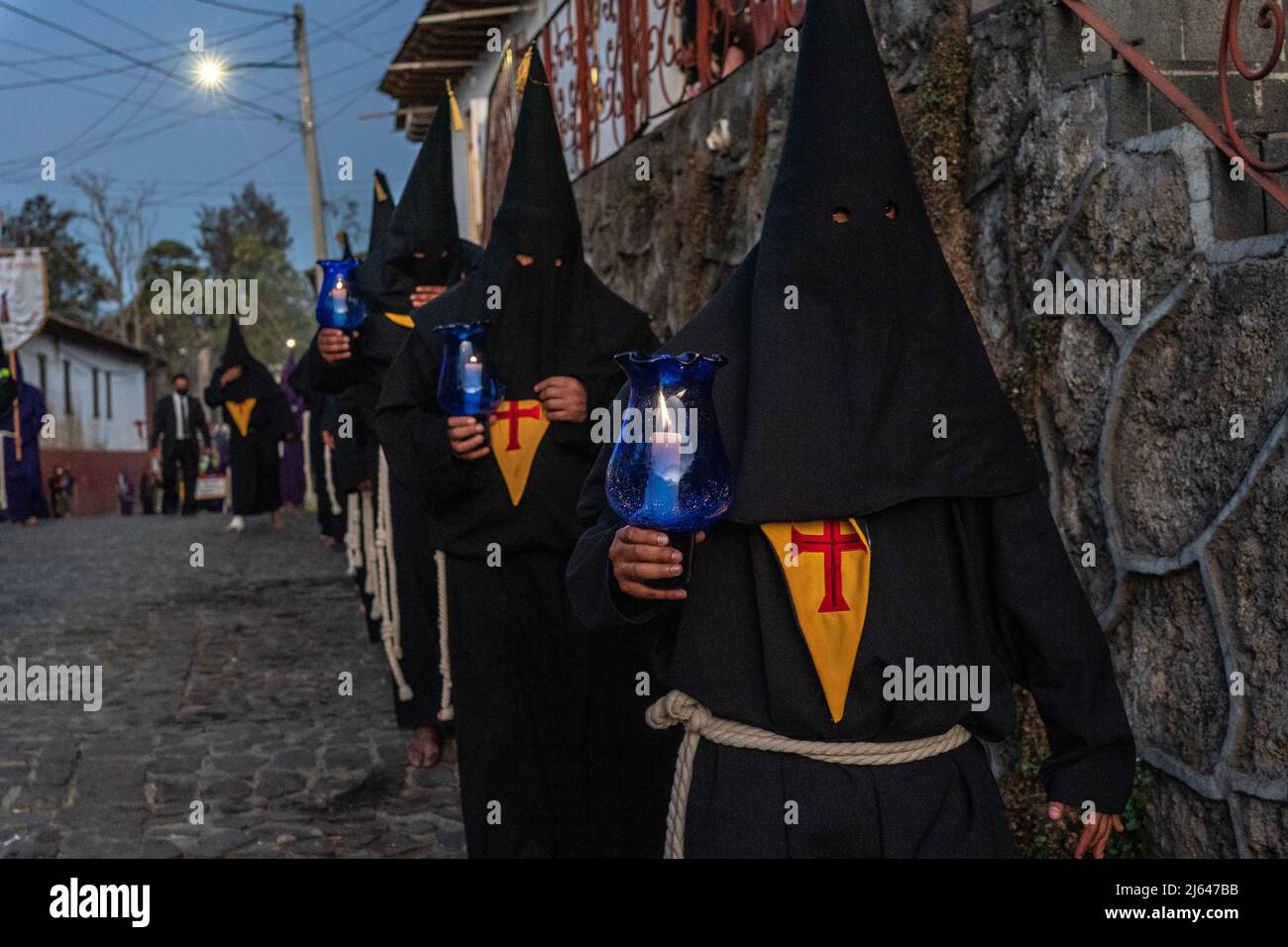 Roman Catholic hooded penitents wearing traditional capirotes, hold a ...