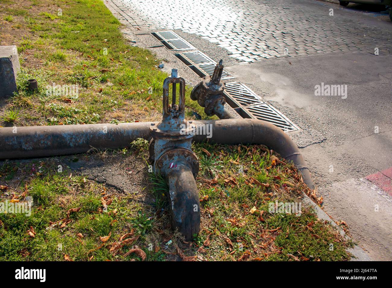 Rusty old water faucet on the background and tubes of water supply ...