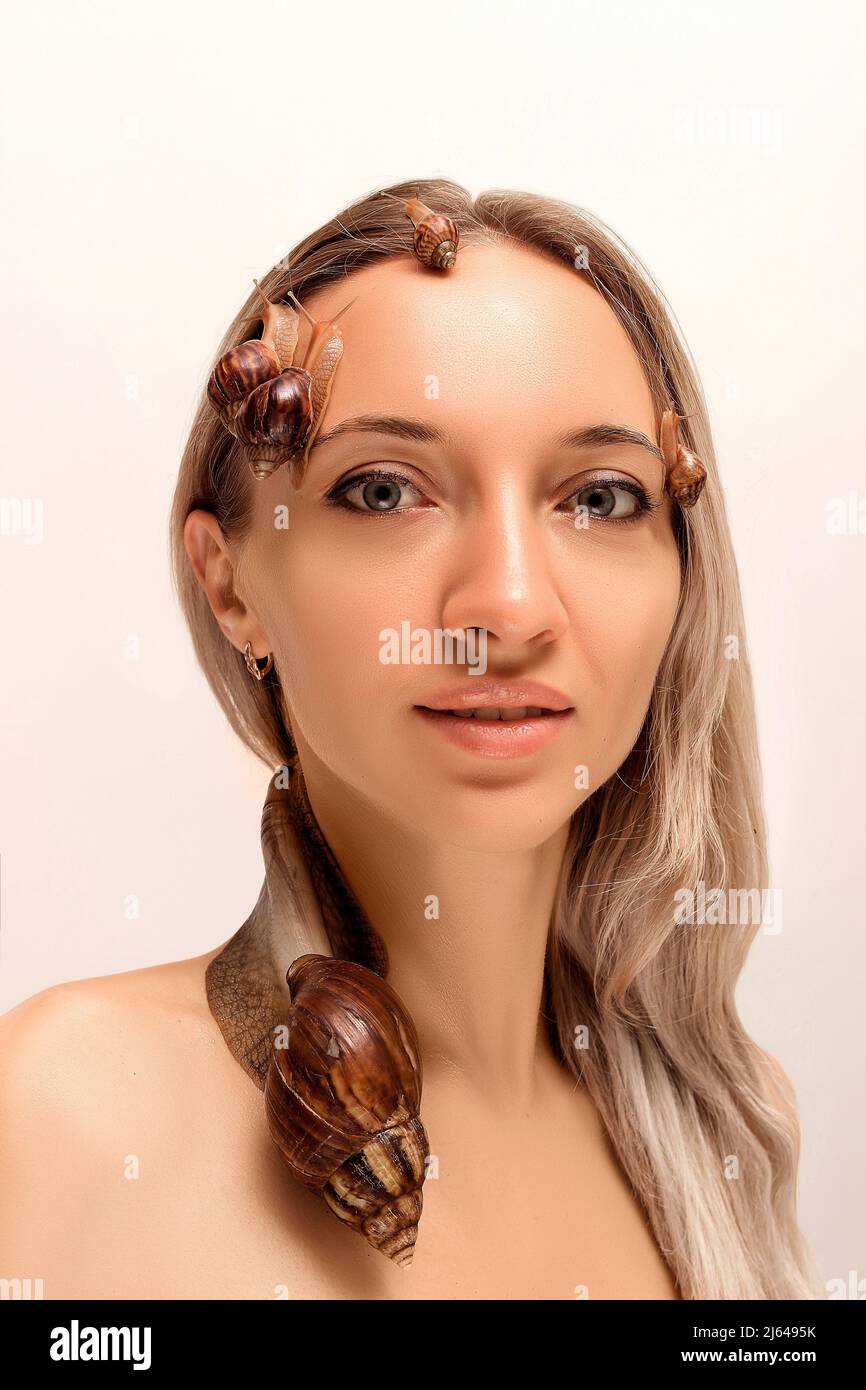 Large and small snails of achatina crawl on the face and neck of a ...