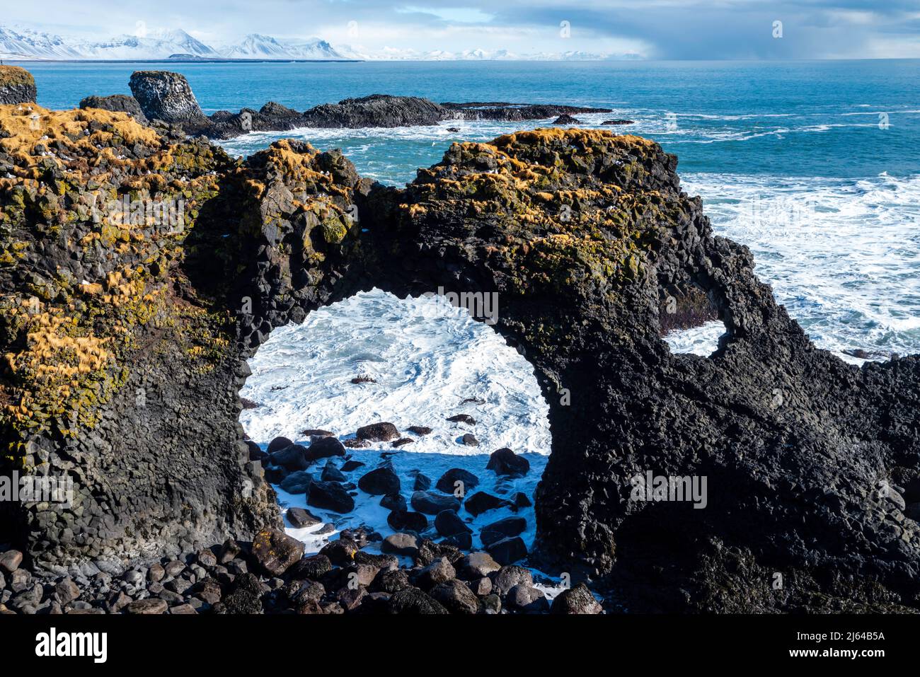 Photograph of the volcanic rock bridge at the Gatklettur Cliff walk ...
