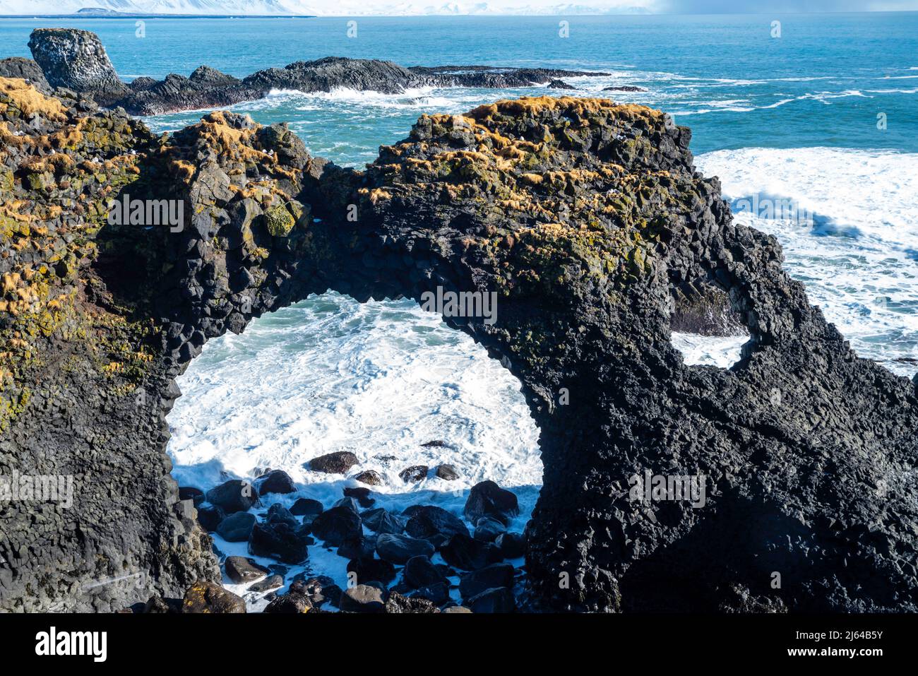 Photograph of the volcanic rock bridge at the Gatklettur Cliff walk ...