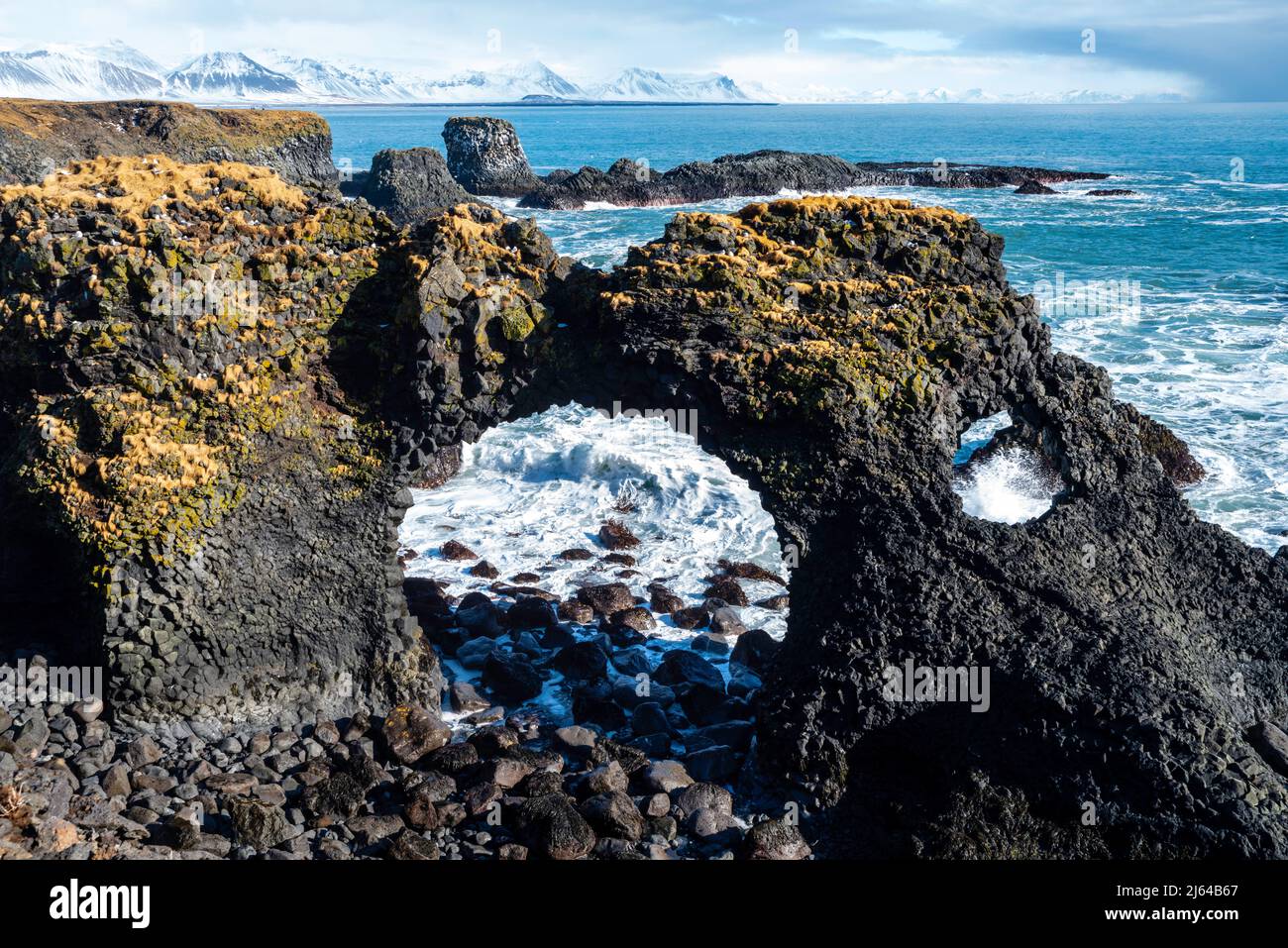 Photograph of the volcanic rock bridge at the Gatklettur Cliff walk ...
