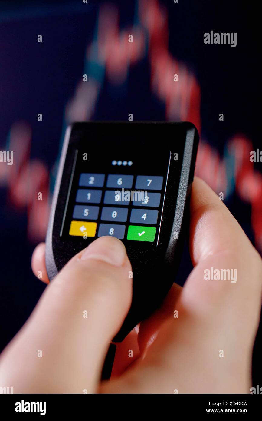 Close up hand enter the password on cryptocurrencey hardware cold ...
