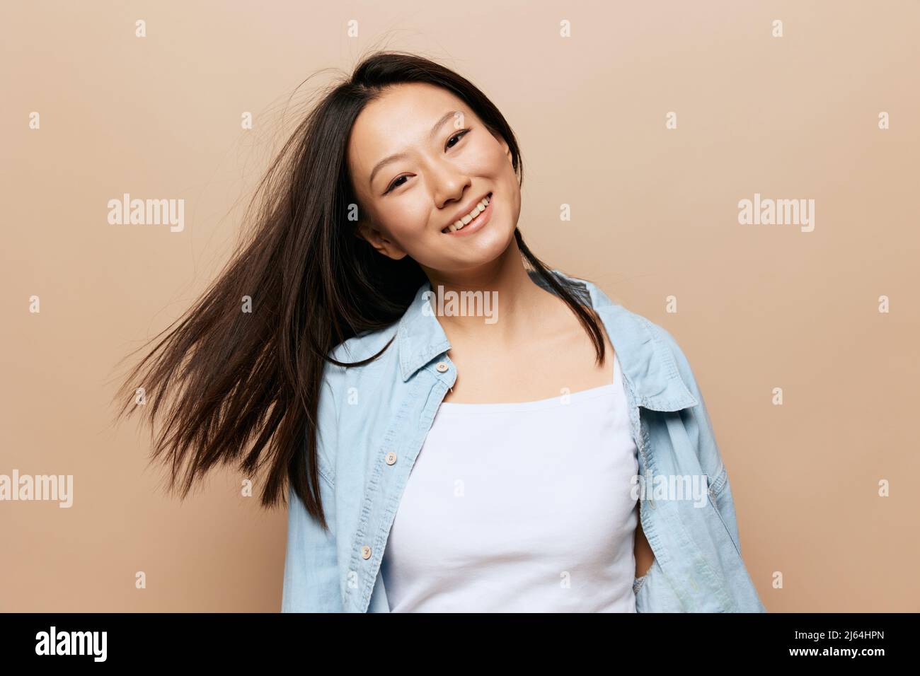 Dancing cheerful tanned adorable young Asian lady spinning waving her ...