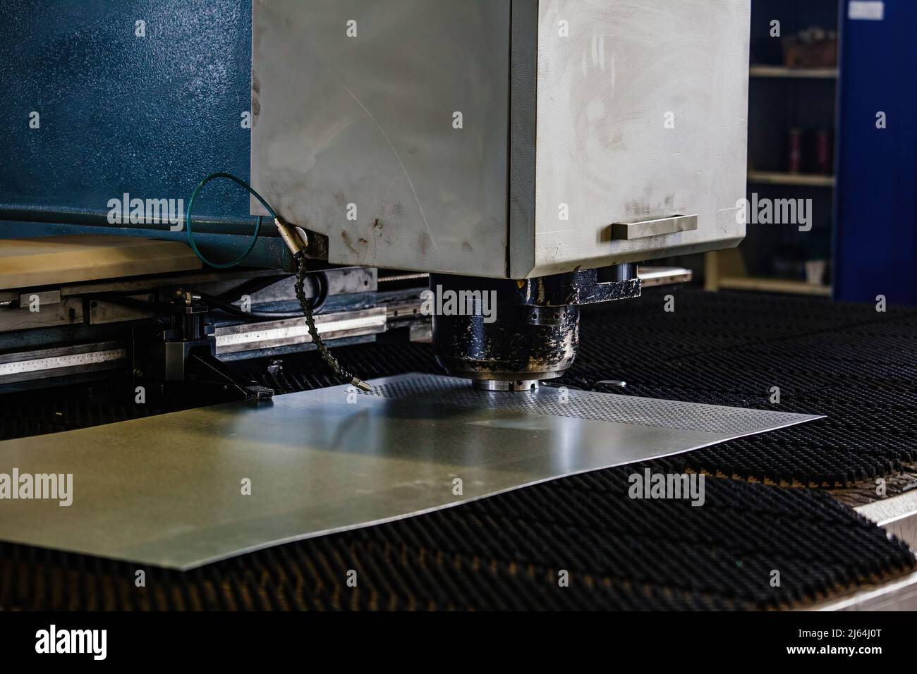 CNC punching and nibbling machine and perforated steel sheet, close up ...