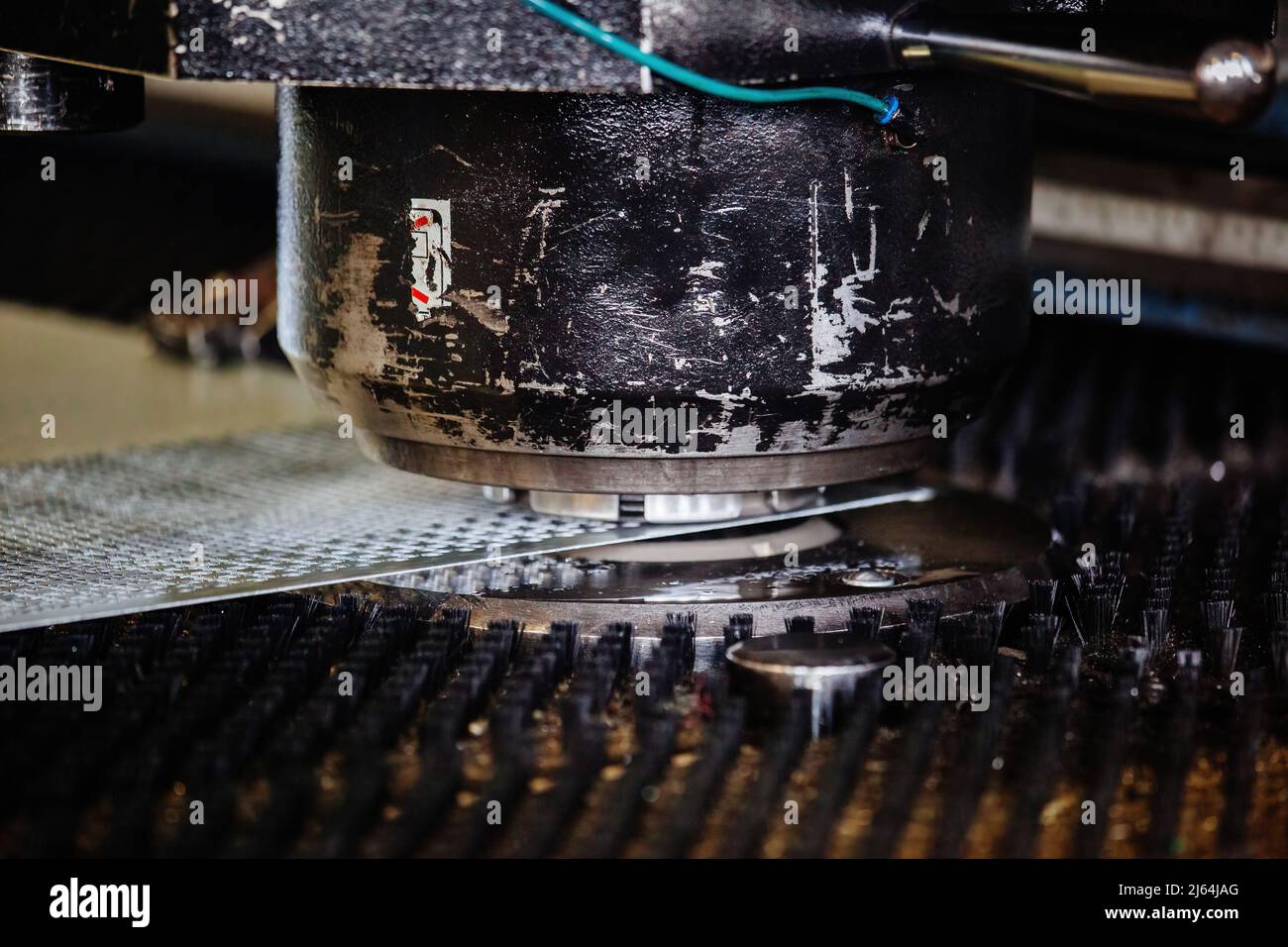 CNC punching and nibbling machine and perforated steel sheet, close up ...