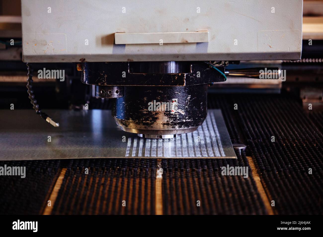 CNC punching and nibbling machine and perforated steel sheet, close up ...