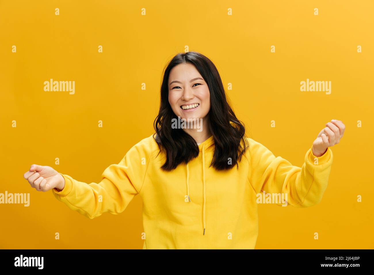 Yeah, I did it. Overjoyed Asian student young woman in yellow hoodie ...