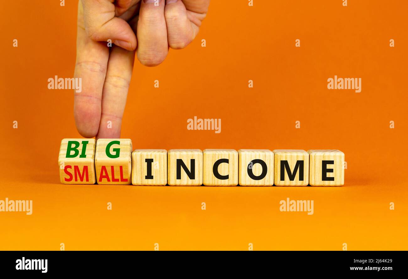 Big or small income symbol. Businessman turns wooden cubes and changes ...