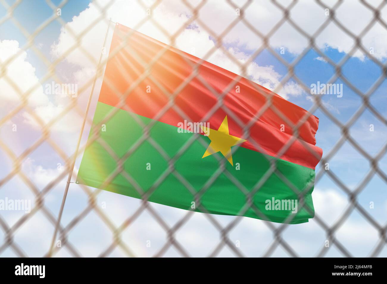 A steel mesh against the background of a blue sky and a flagpole with ...