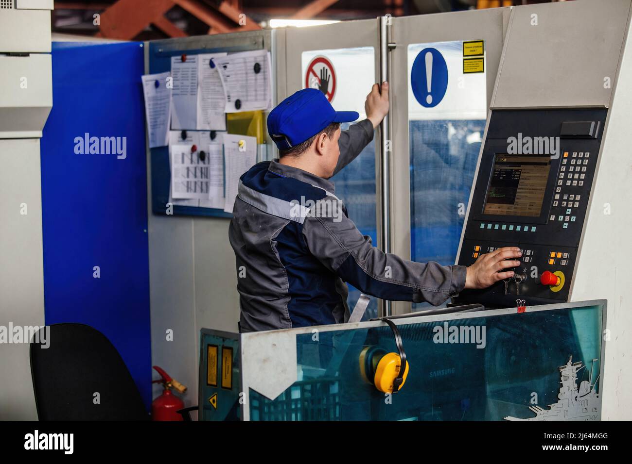 Factory worker operating CNC machine in metalworking workshop Stock ...