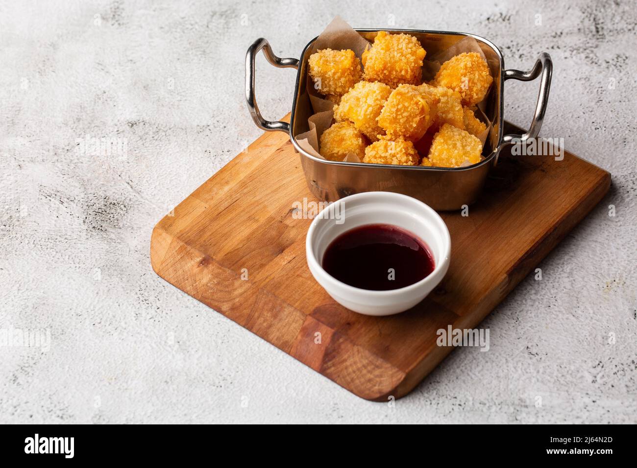 Deep fried Cheese squares served with cranberry sauce in marble ...