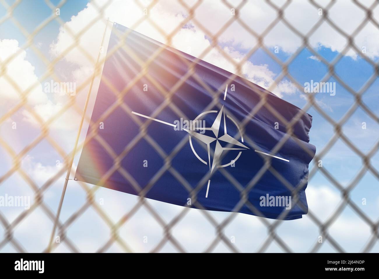 A steel mesh against the background of a blue sky and a flagpole with ...