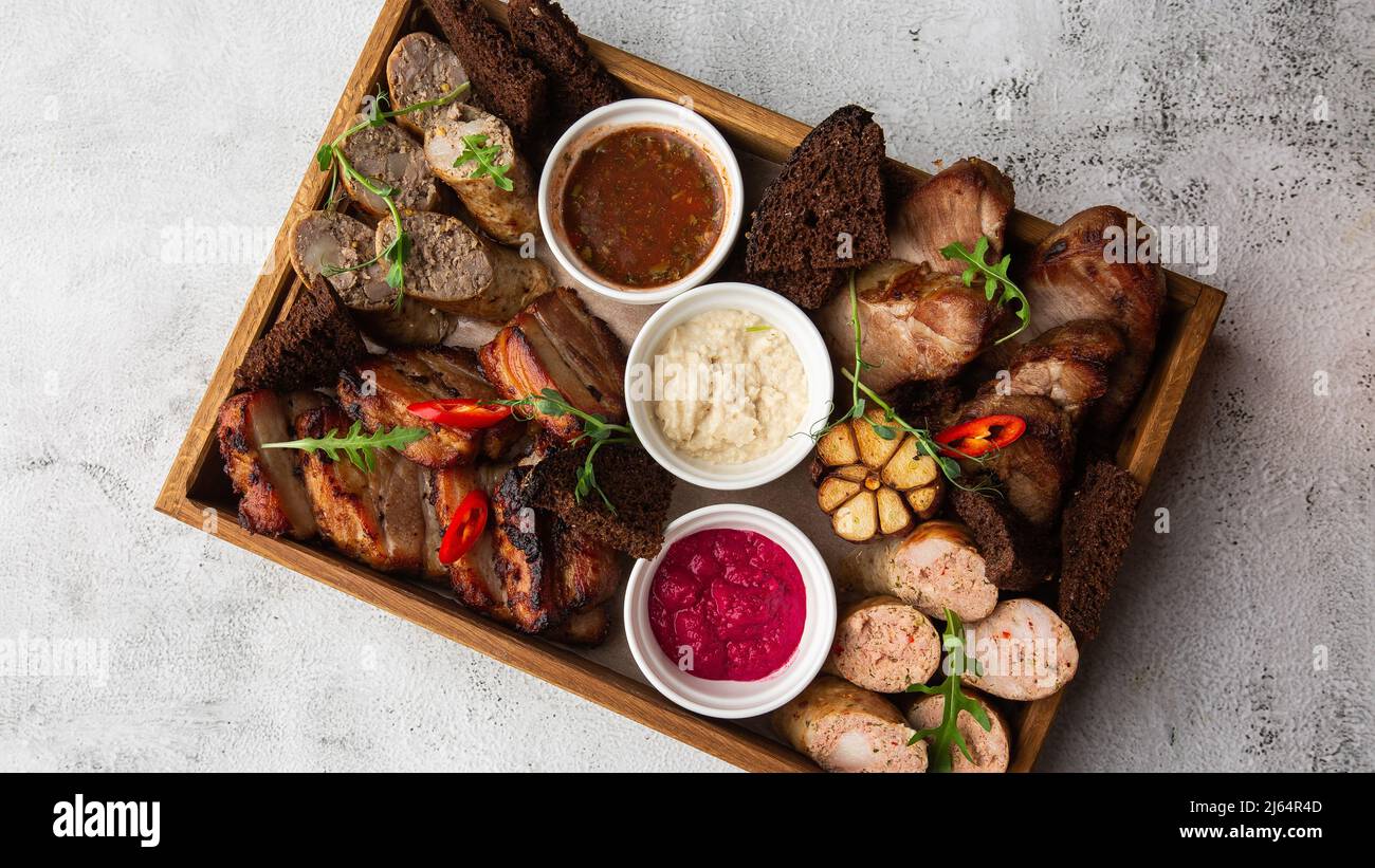 Close-up photo of mixed grilled meat platter. Beef, pork, poultry, sausages, grilled garlic ...
