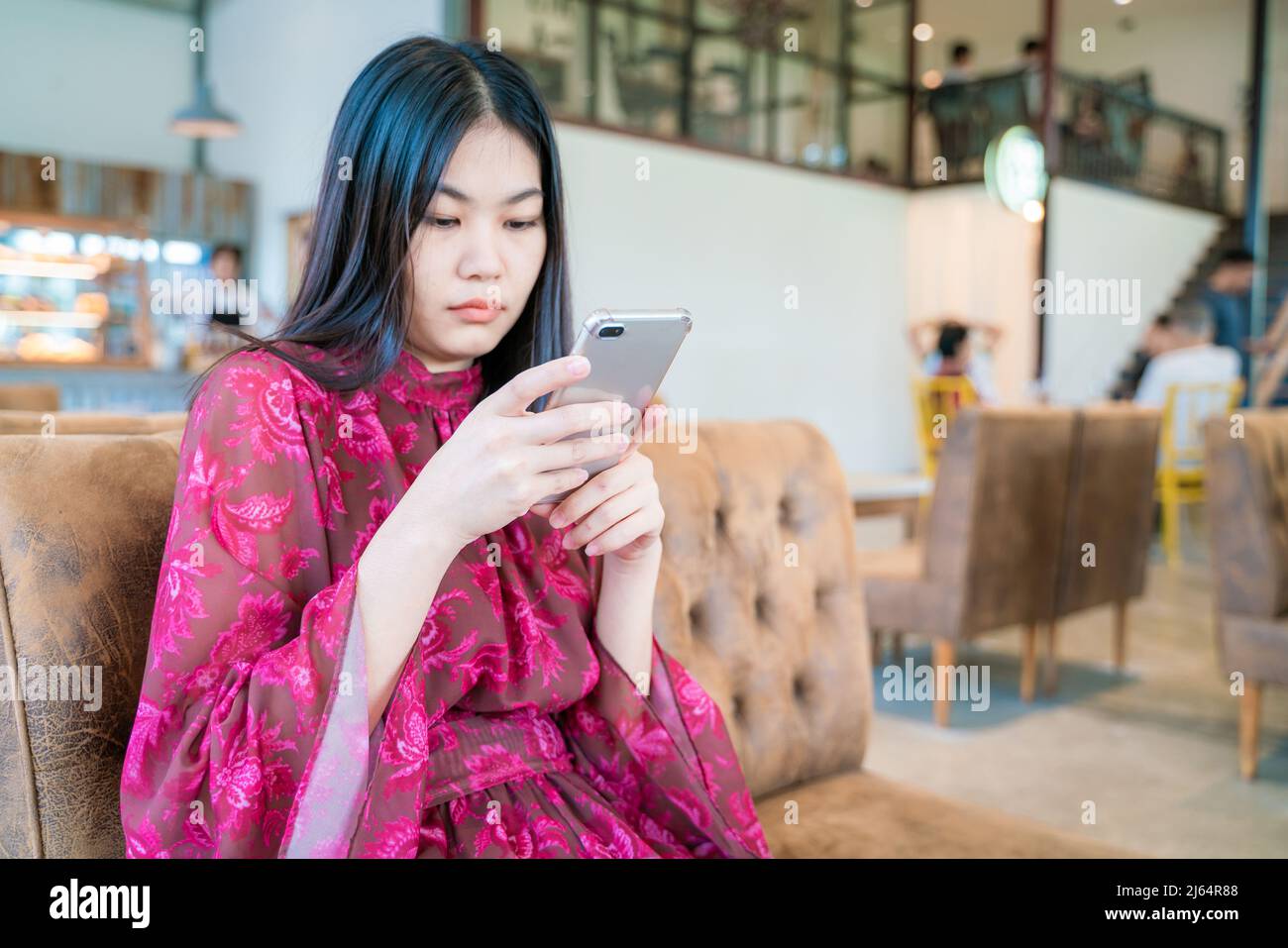 Beautiful asian women texting message on smartphone sitting in coffee ...