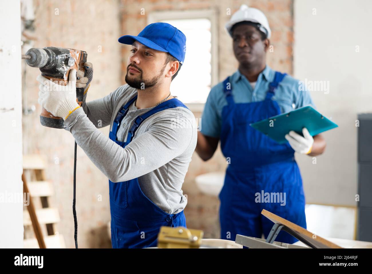 Confident builder posing on indoor construction site Stock Photo - Alamy